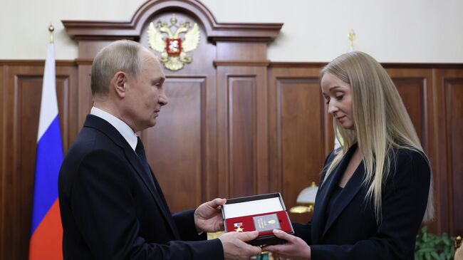 Президент РФ Владимир Путин передает вдове Героя России генерал-майора Михаила Гудкова Жанне Гудковой медаль Золотая Звезда. 6 июля 2025