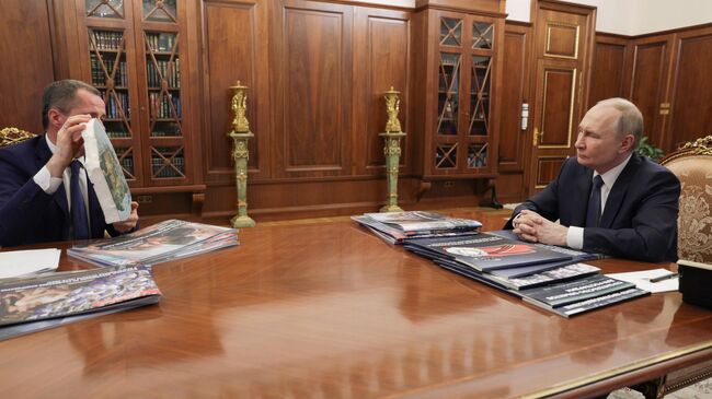 Губернатор Белгородской области Вячеслав Гладков передает президенту РФ Владимиру Путину картину белгородской художницы, выполненную на осколке крышки корпуса ракеты ПВО С-400